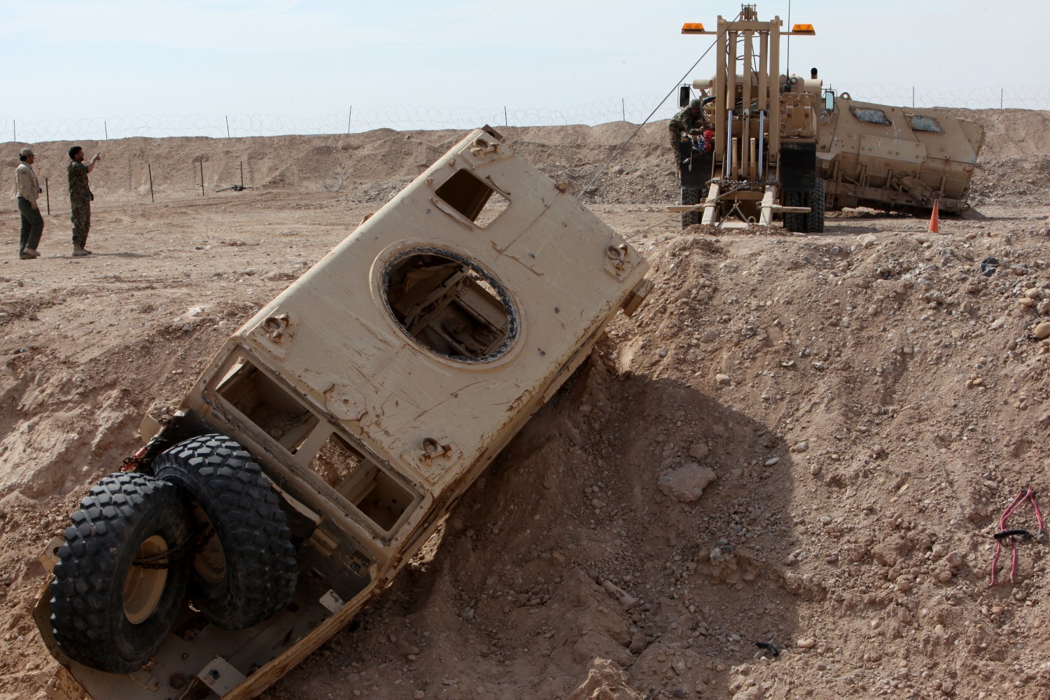 An Afghan soldier operates an interim Stryker recovery system to pull a ...