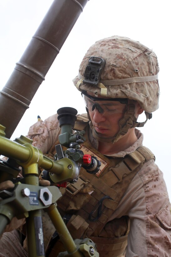 U.S. Marine Corps Lance Cpl. Eric Donnelly adjusts the sights on an M224 60-mm mortar system ...