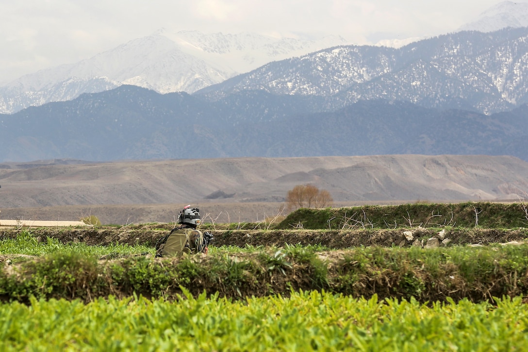 An Afghan army commando bounds toward a compound after taking enemy ...