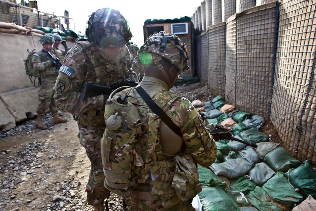 U.S. Army Lt. Col. Robert Owen, left, checks weapons before attending a ...