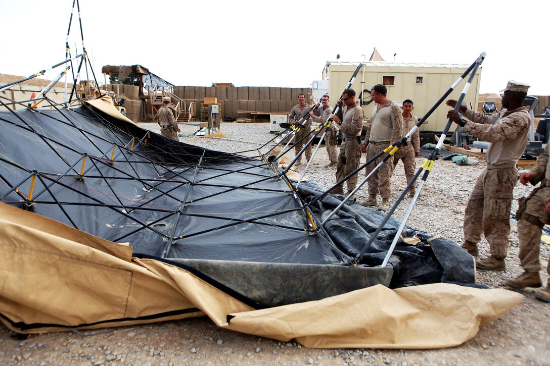 U.S. Marines and sailors take down a tent on Forward Operating Base ...