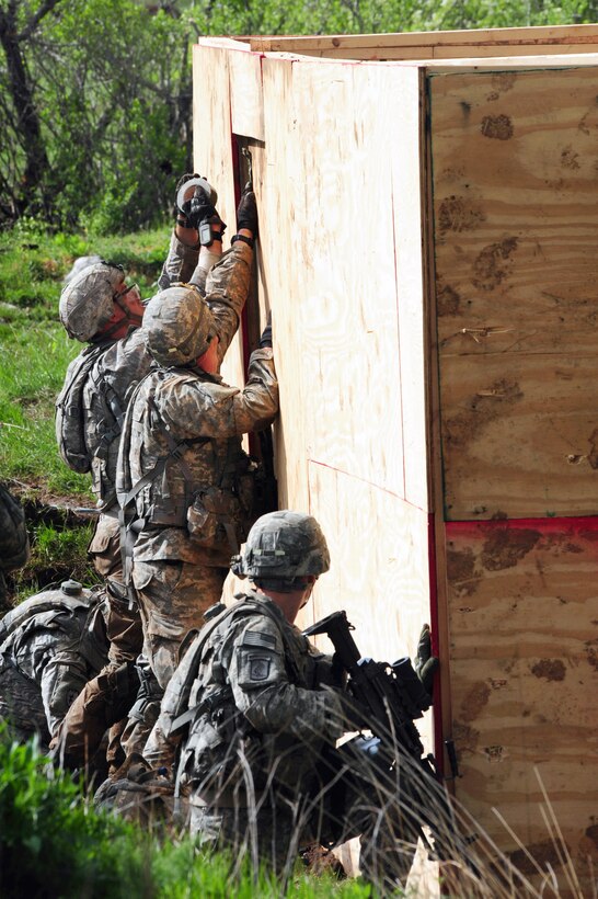 U.S. paratroopers prepare to breach a building using explosives during ...