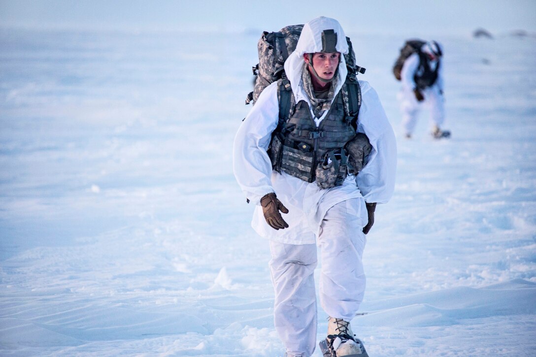 Army Sgt. Steven Calloway snowshoes across the tundra after an airborne ...
