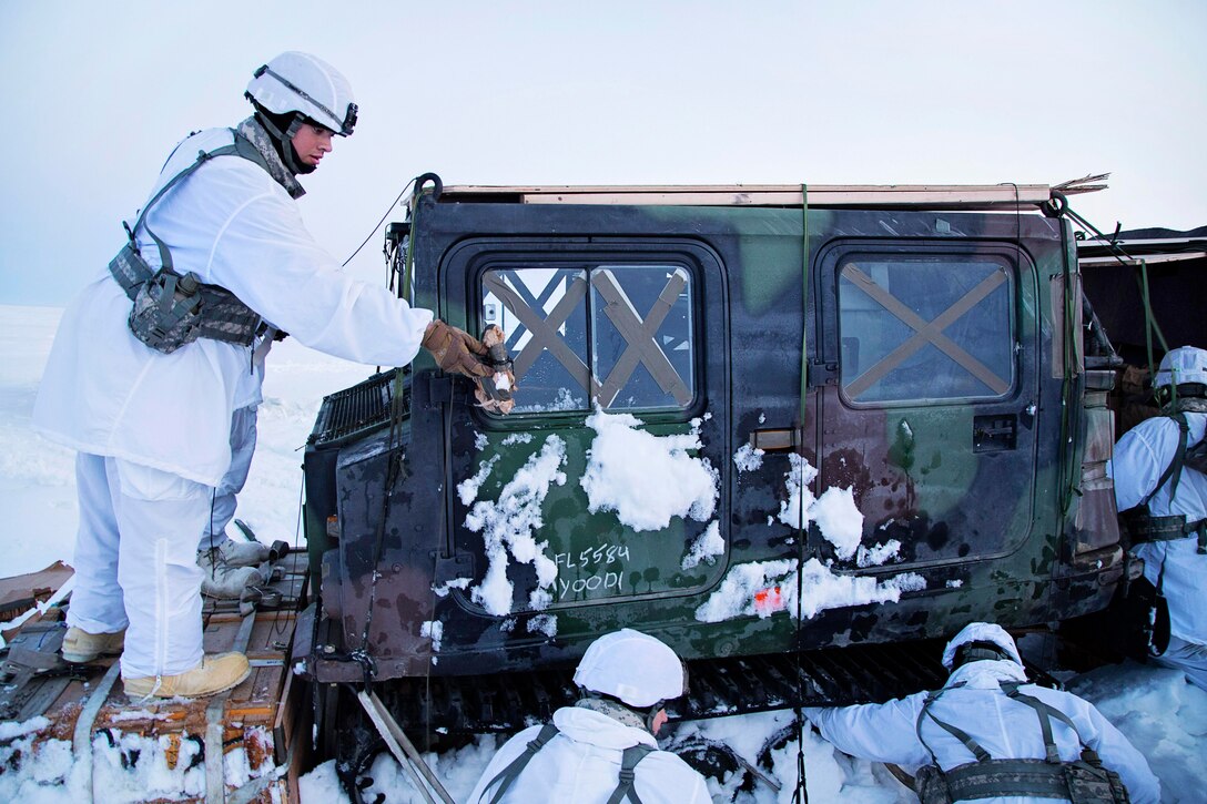 Army Sgt. Jeremy Hazard, left, unpacks a small support vehicle dropped ...