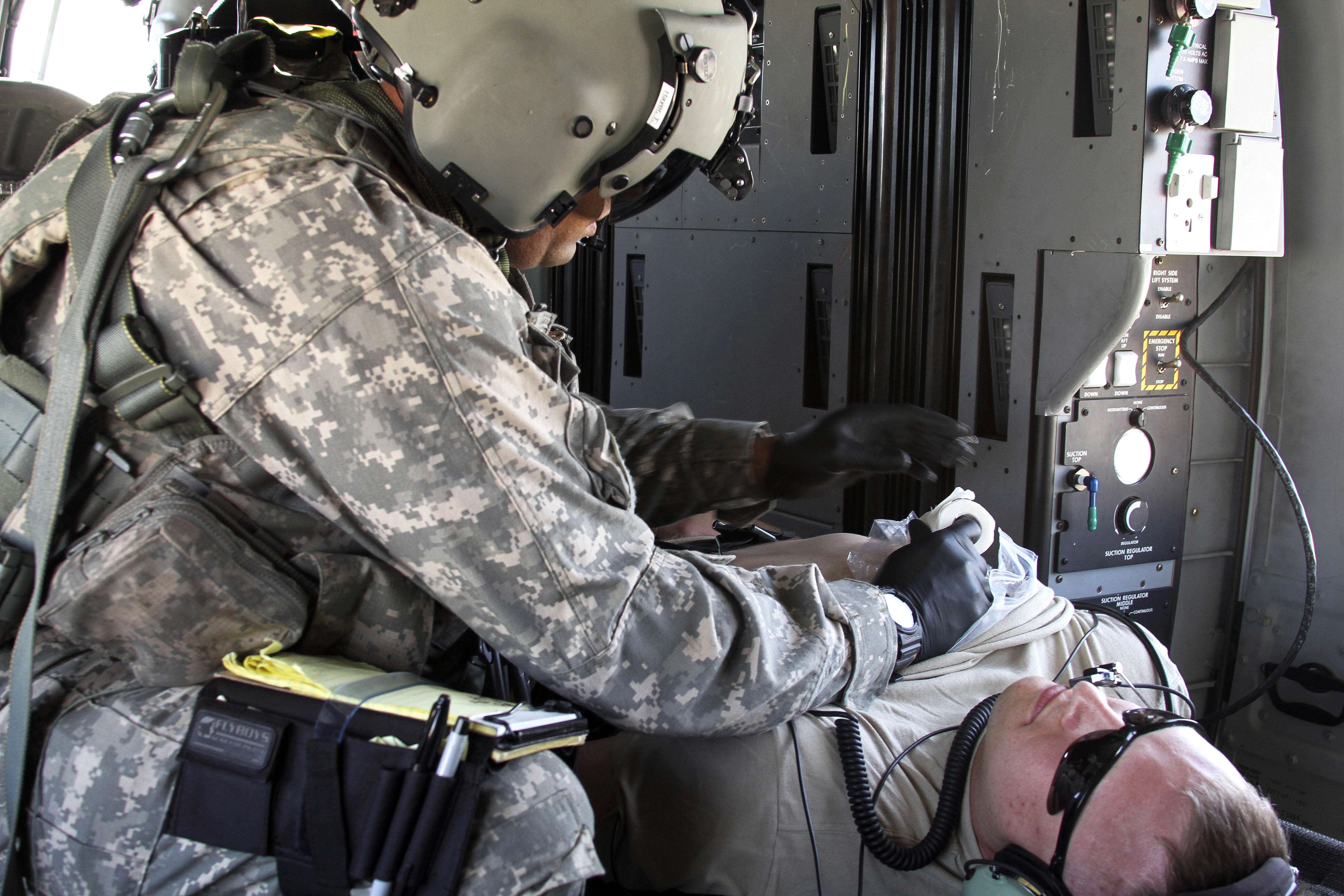 Army Spc. T.J. Hayer, left, simulates treating a chest wound inside an ...