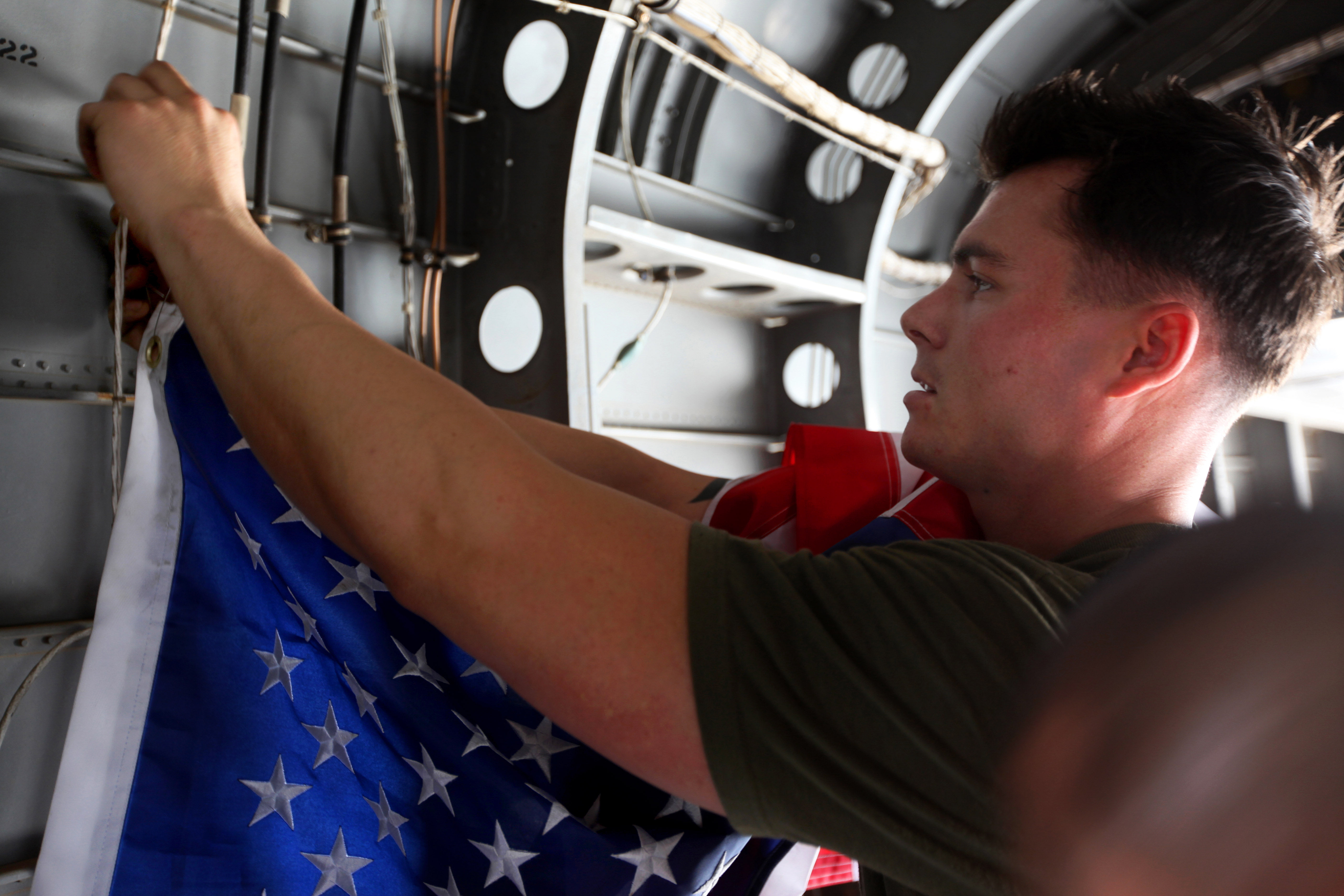 U.S. Marine Corps Cpl. Ryan Roberts hangs the U.S. flag inside the ...