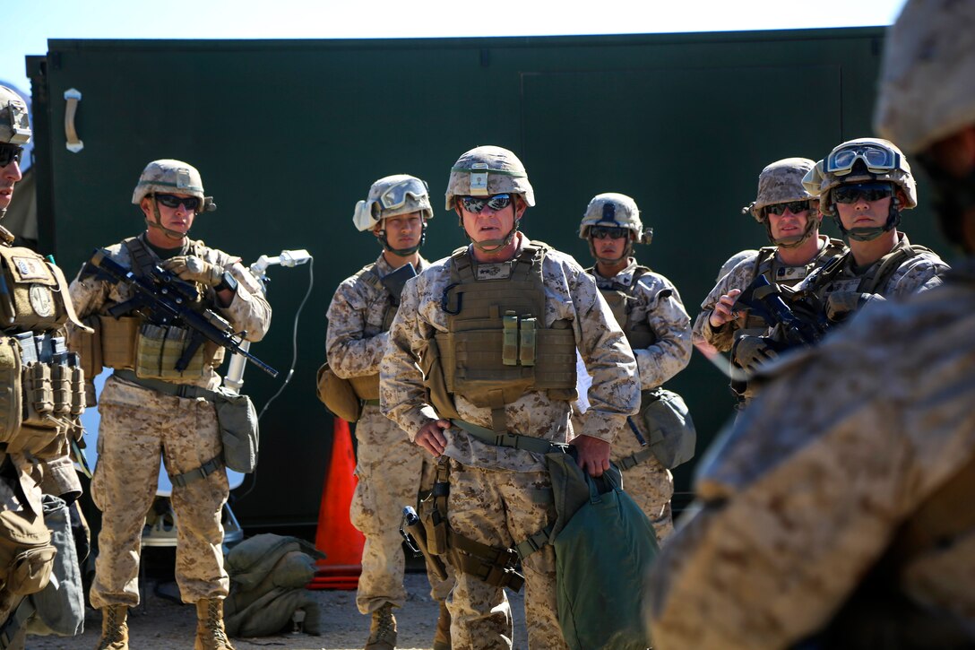 Marine Corps Maj. Gen. Lawrence D. Nicholson, center, listens to a ...