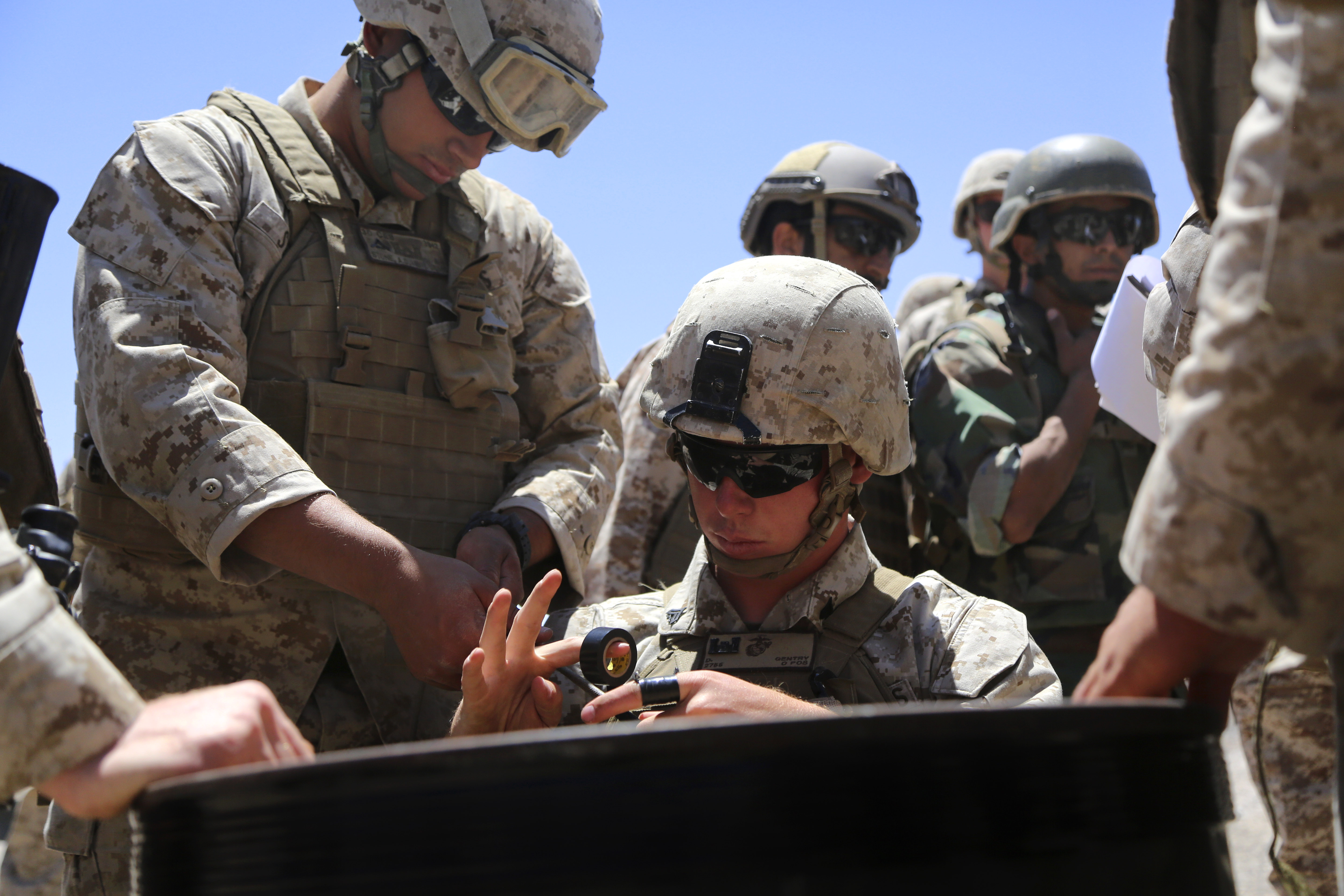 Marine Corps Cpl. Dustan G. Gentry, center, prepares a detonation cord ...