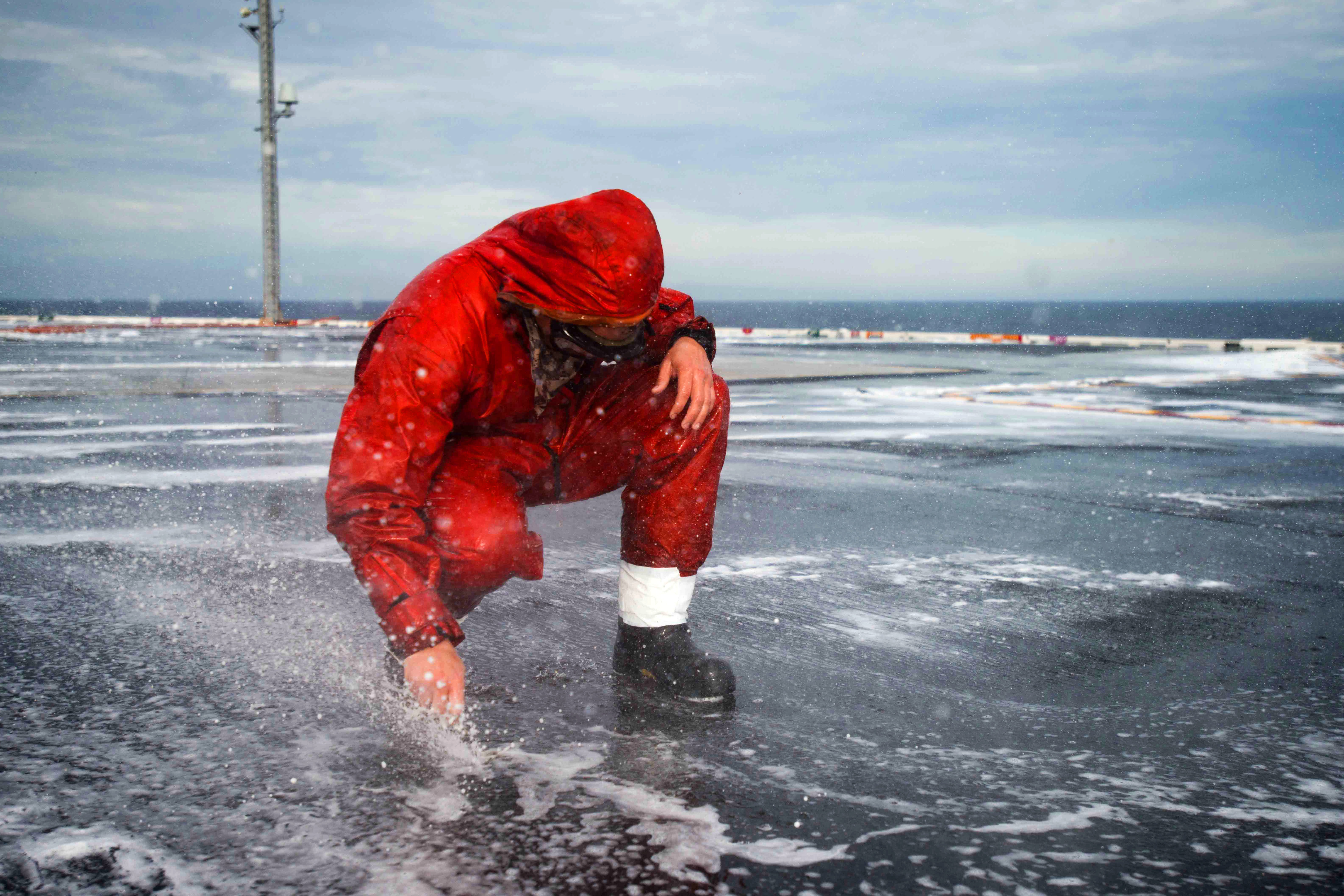 Navy Petty Officer 3rd Class Travis Beach unclogs an aqueous film ...