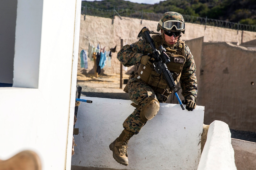 Marine Corps Sgt. Justin Leduc jumps over a barrier in an urban ...
