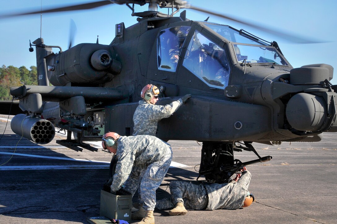 Soldiers perform maintenance on an AH-64D Apache helicopter before ...