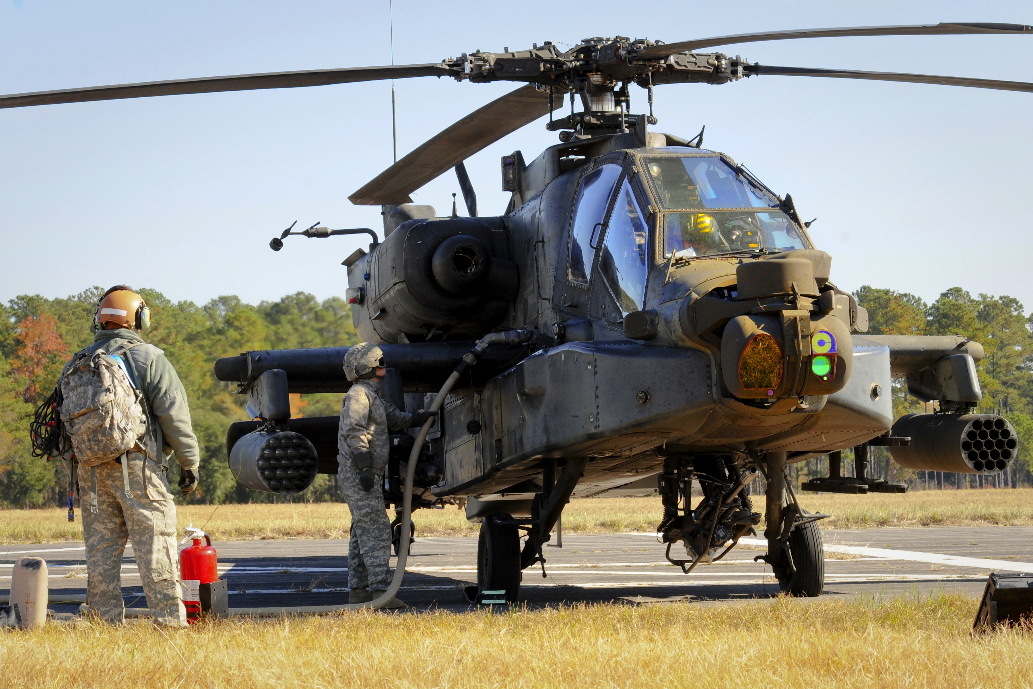 Army Sgt. Britany DeMichele, center, refuels an AH-64D Apache ...