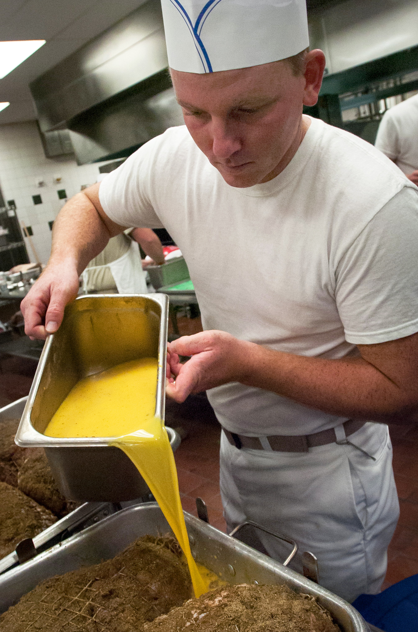 A soldier bastes turkeys for a Thanksgiving Day meal on Eglin Air Force ...