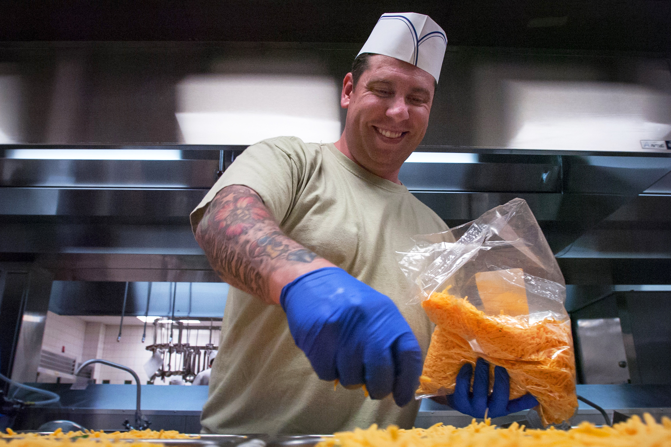 A soldier adds cheese to green bean casseroles for a Thanksgiving Day ...