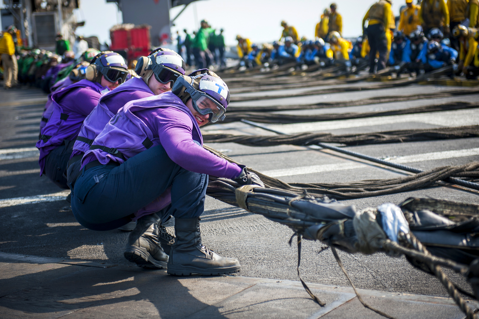 U.S. sailors rig the barricade during a flight deck drill on the ...