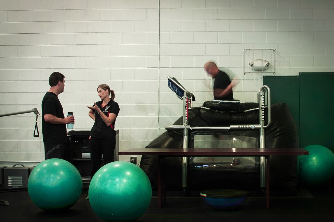 A soldier, right, runs on an anti-gravity treadmill while Dana Terrell ...