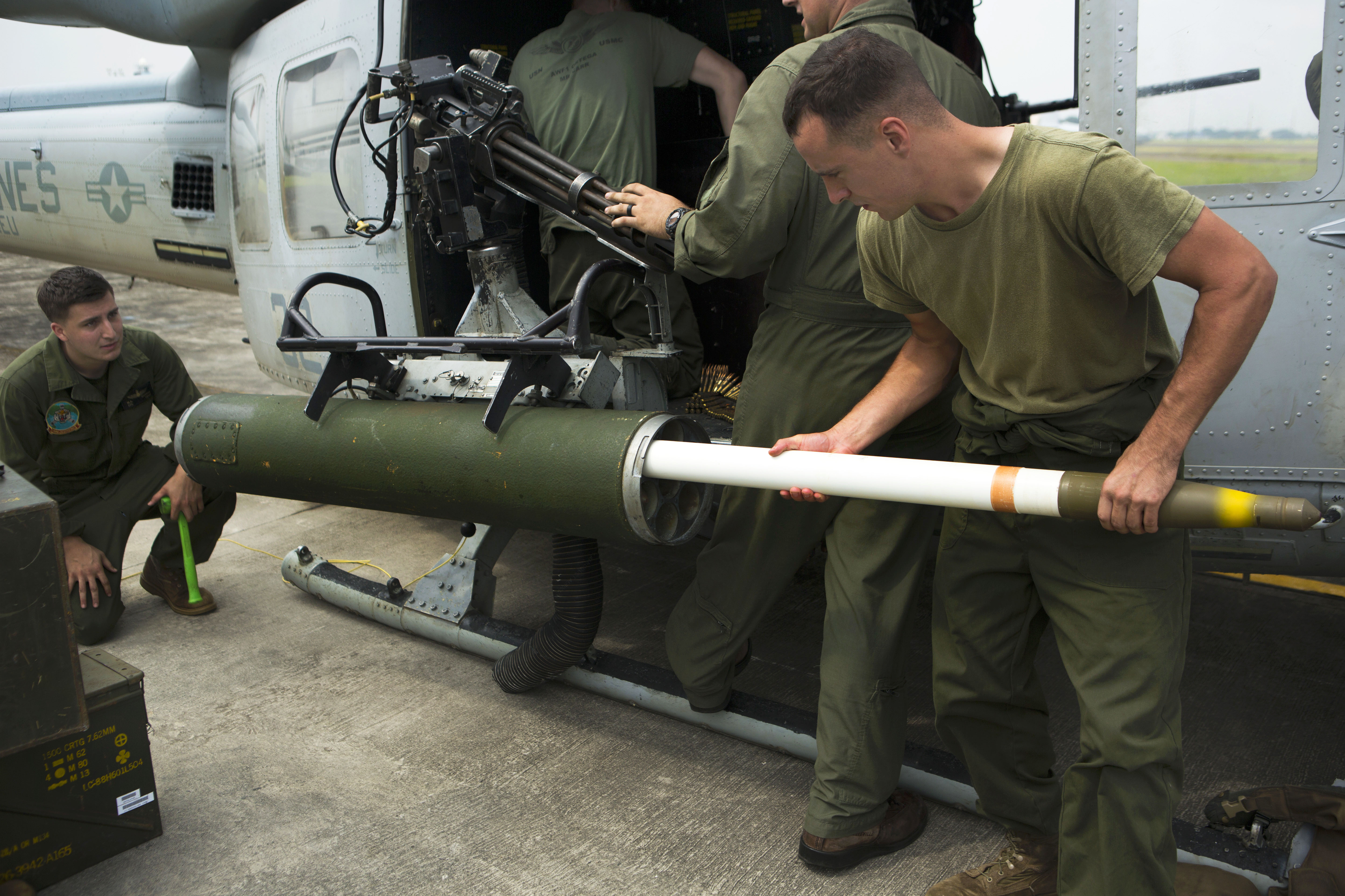 U.S. Marines load rockets onto a UH-1Y Venom helicopter before takeoff ...