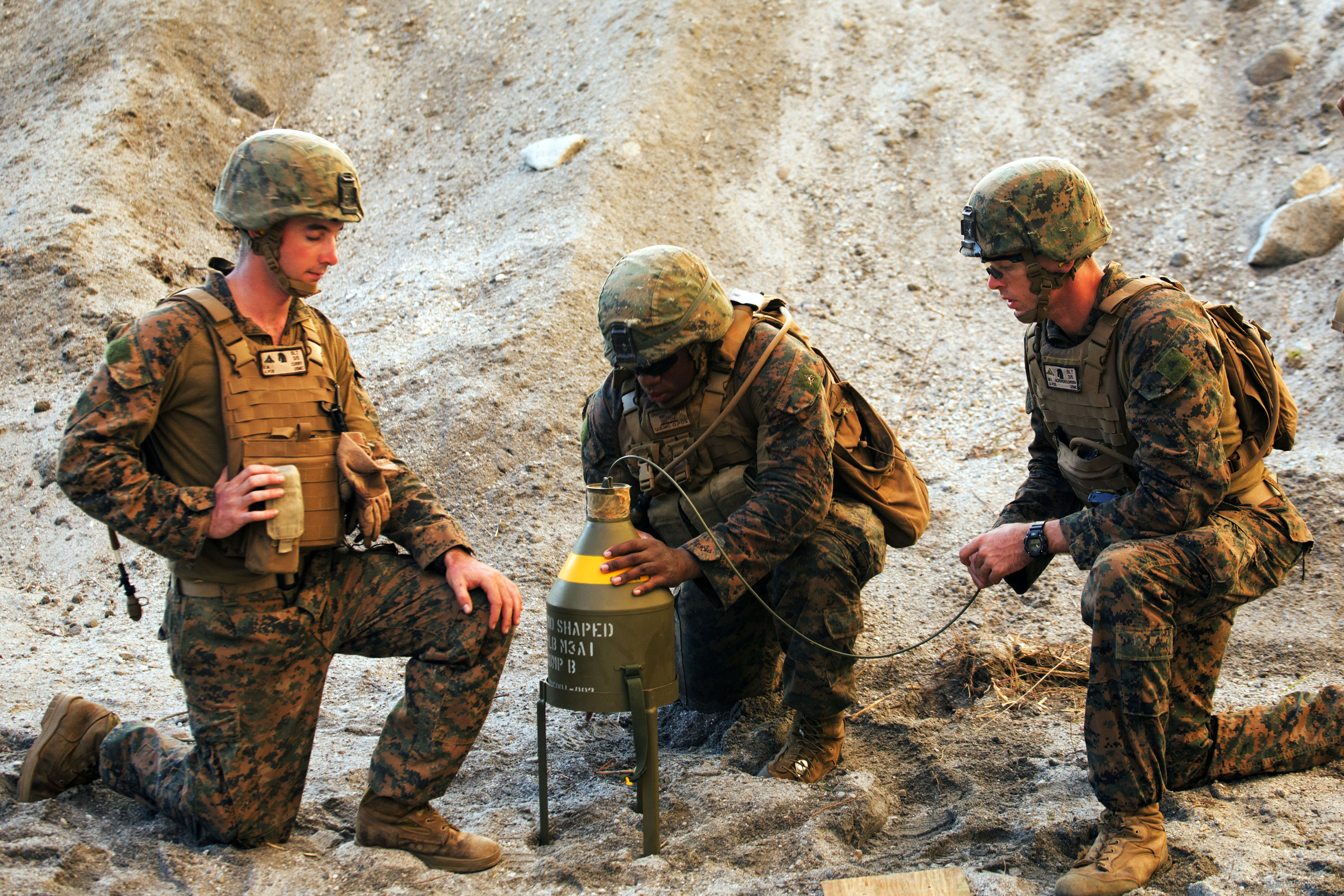 U.S. Marine Corps Cpl. Malcom L. Crafton, middle, explains how to place ...
