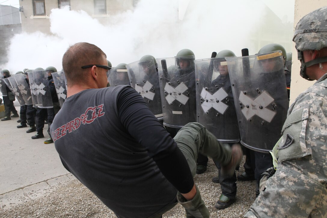 A U.S. soldier, center, playing the role of a simulated rioter, kicks ...