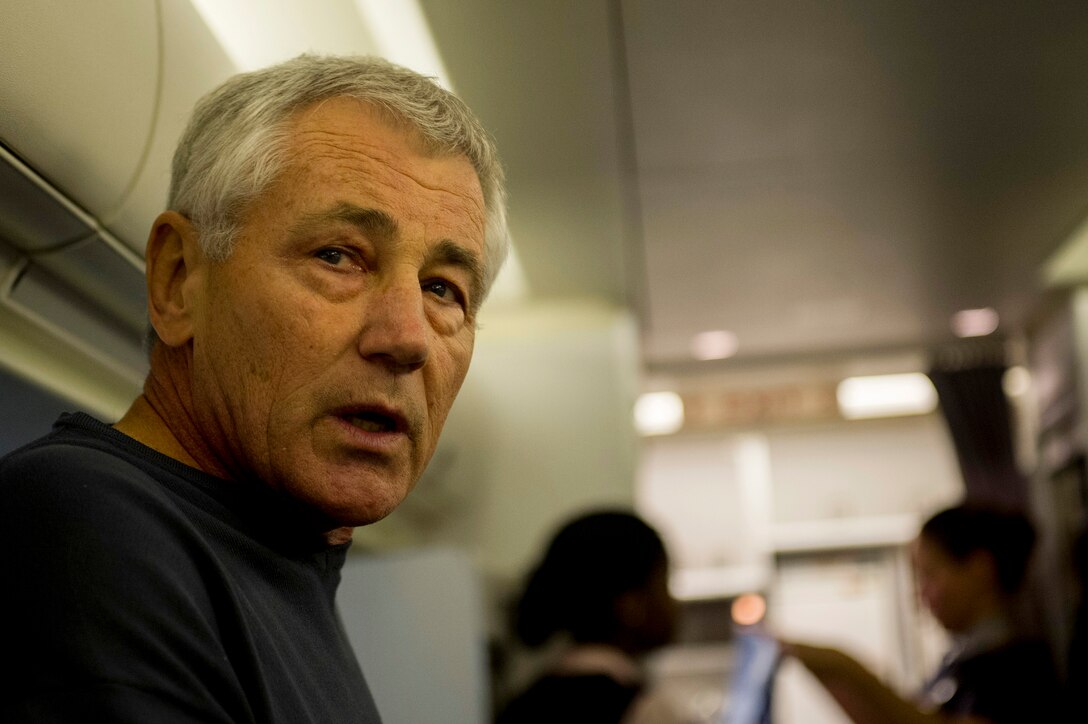 U.S. Defense Secretary Chuck Hagel speaks with reporters on a flight ...