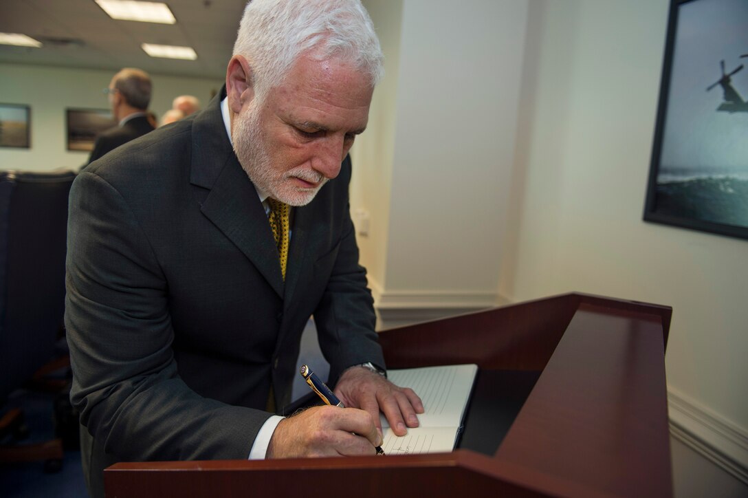 Dan Harel, director general of Israel's defense ministry, signs the ...