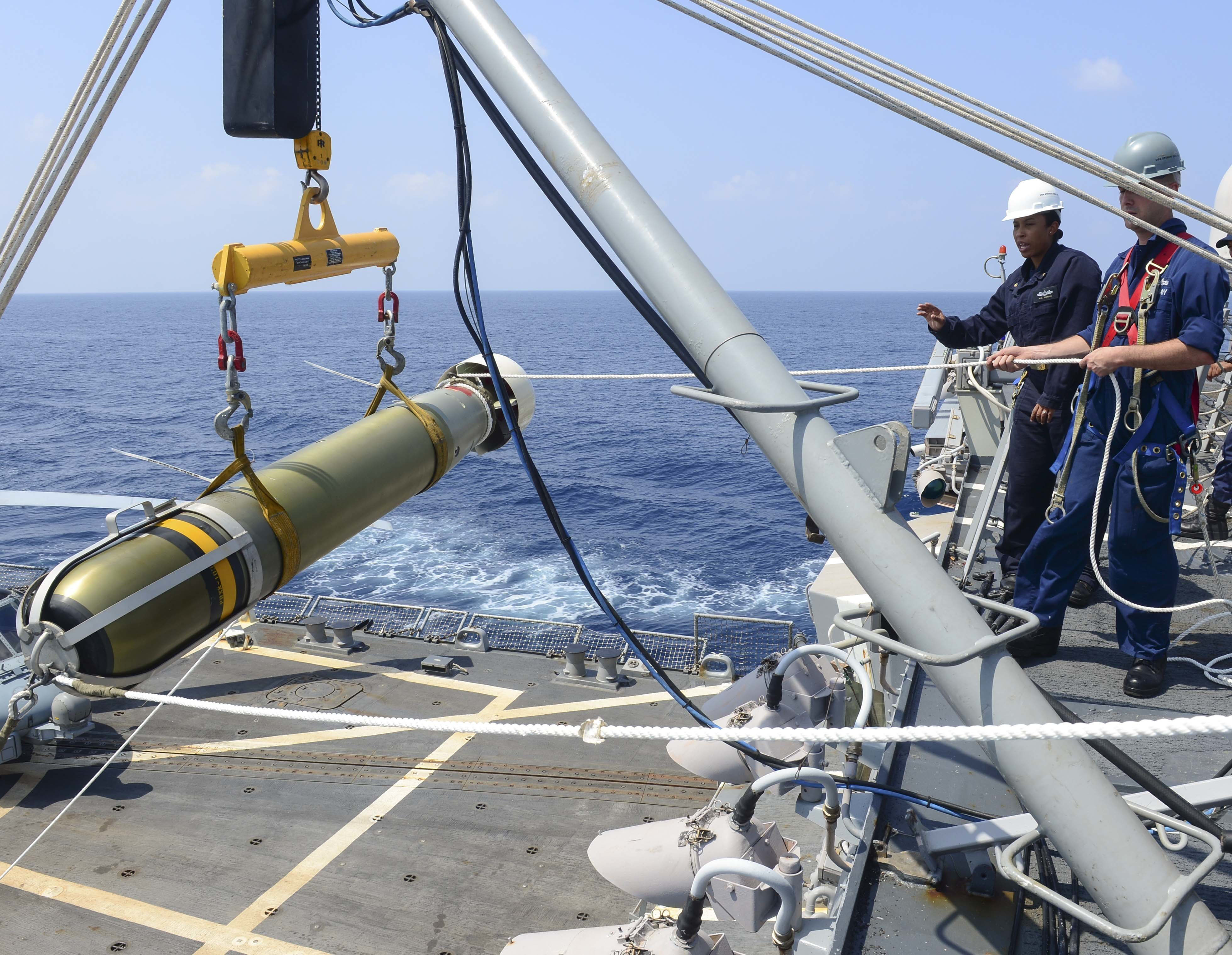 U.S. sailors on the guided missile destroyer USS Sterett hoist a ...