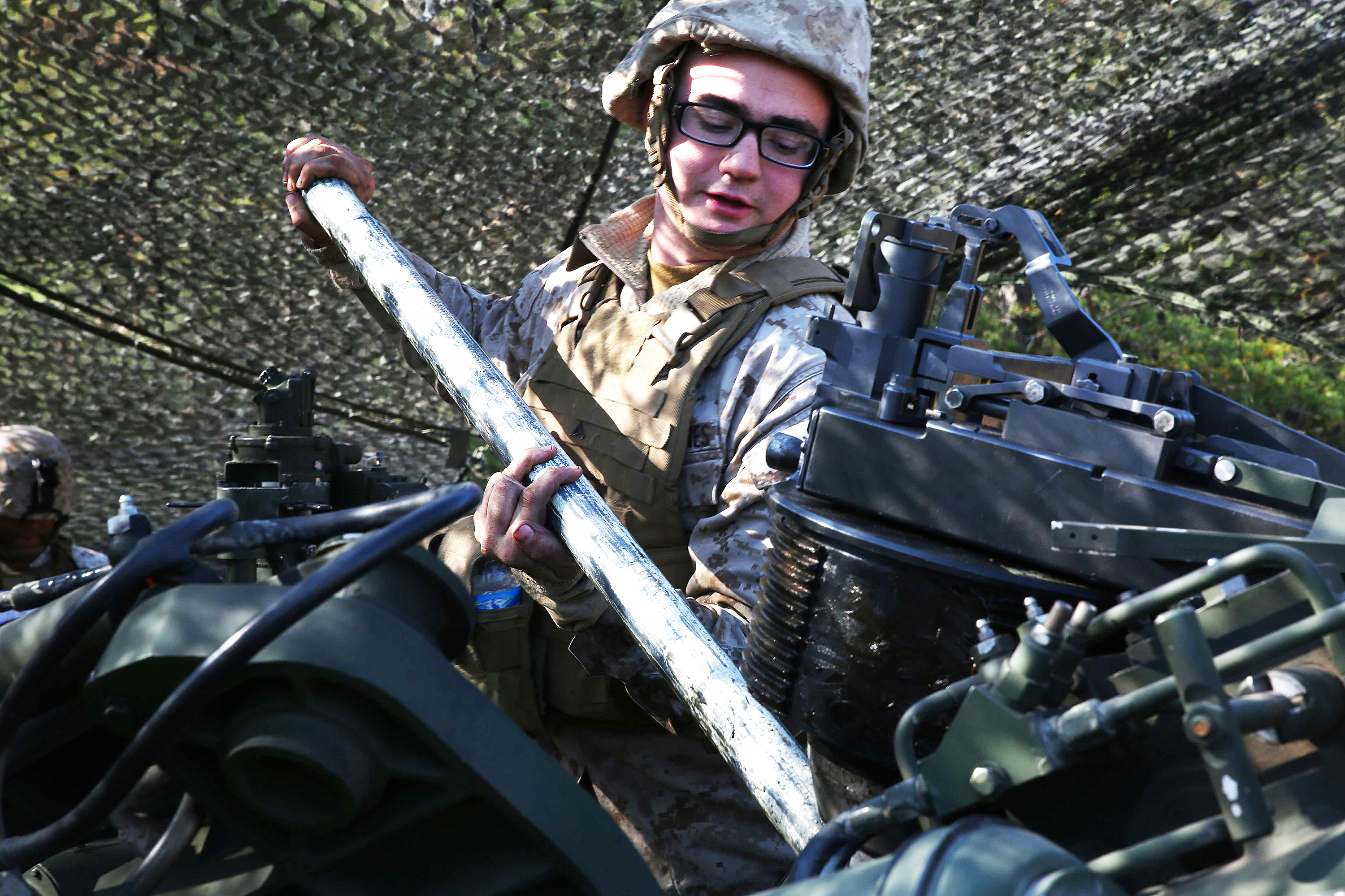 Marine Corps Lance Cpl. James Conley cleans the barrel of the M777A2 ...