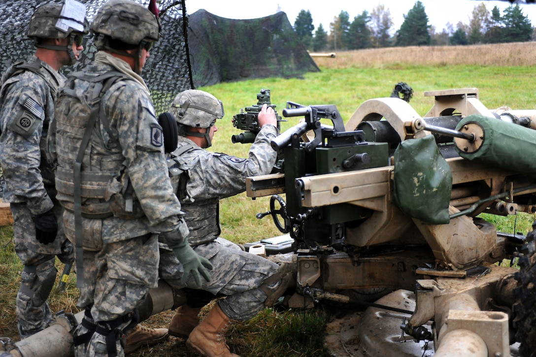 U.S. paratroopers prepare a M119A2 howitzer for a live-fire exercise on ...