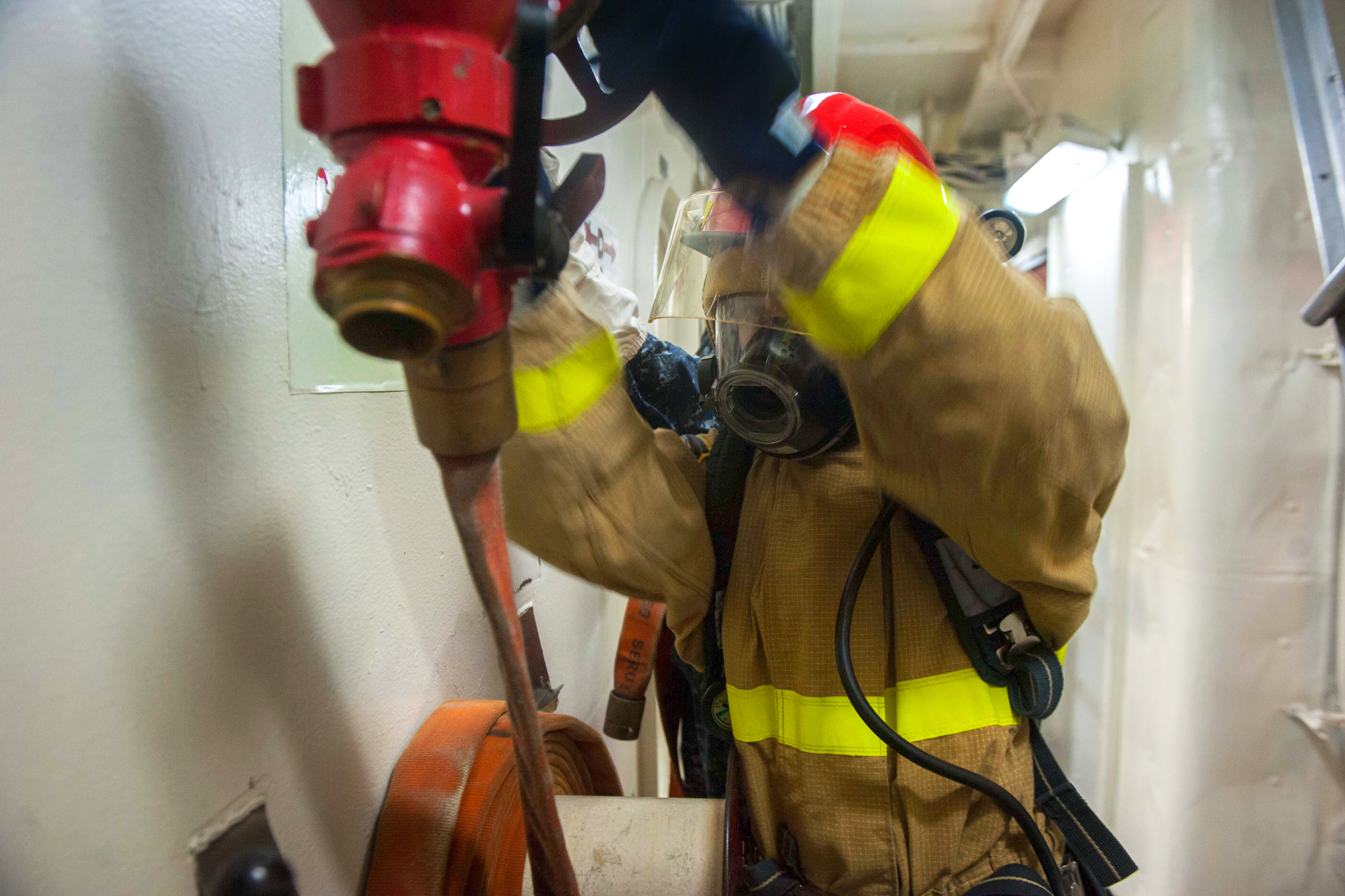 Navy Petty Officer 2nd Class Zachary Turner opens a fire main valve ...