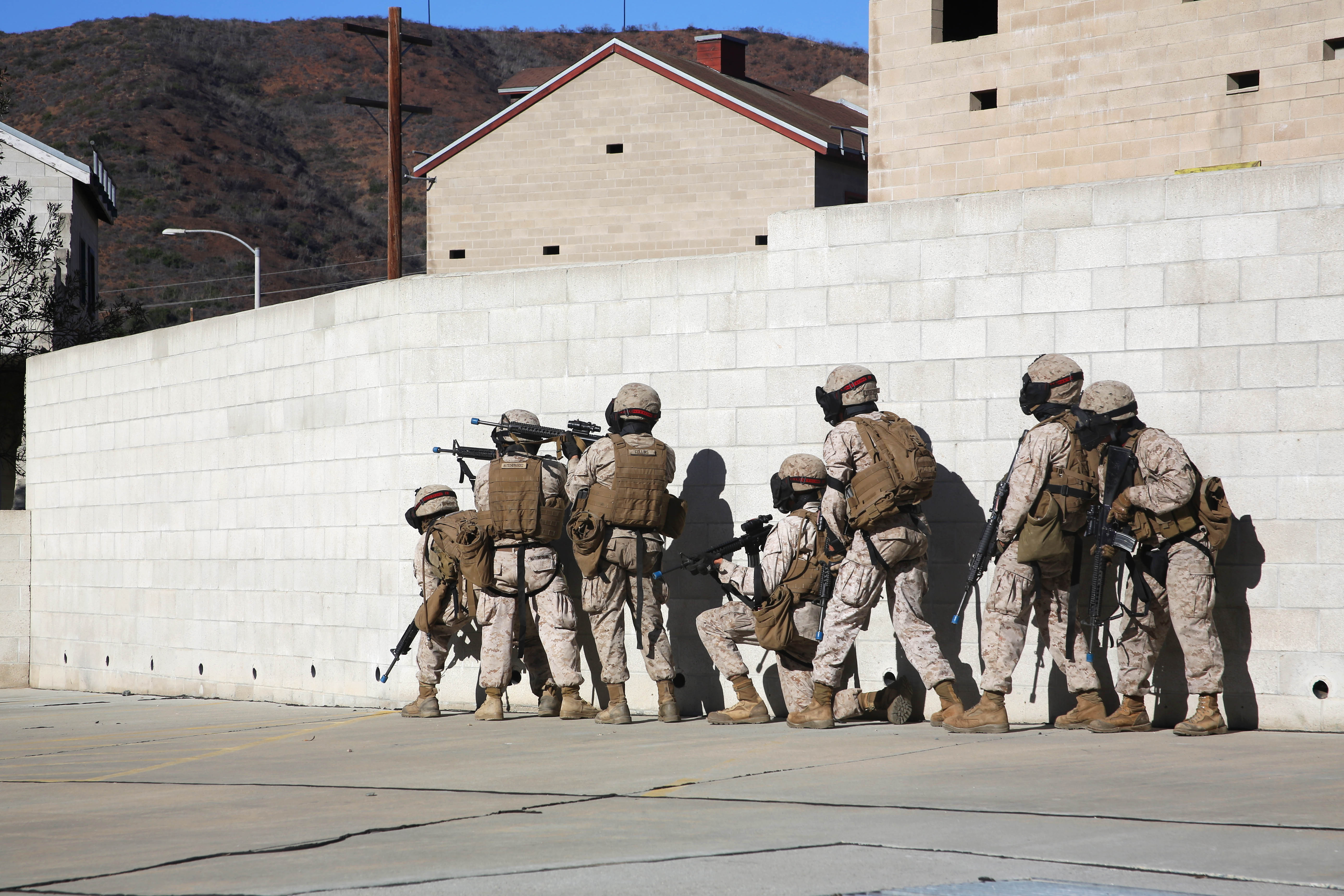 Marines take cover behind a wall during a training evolution using ...