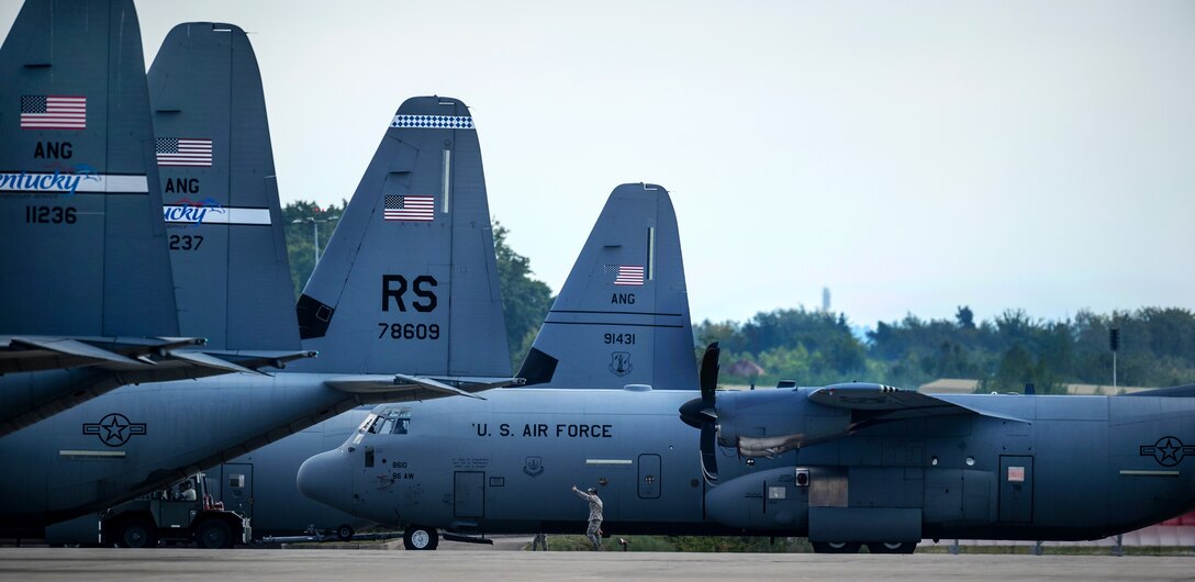 U.S. airmen tow a 37th Airlift Squadron C-130J Super Hercules aircraft ...