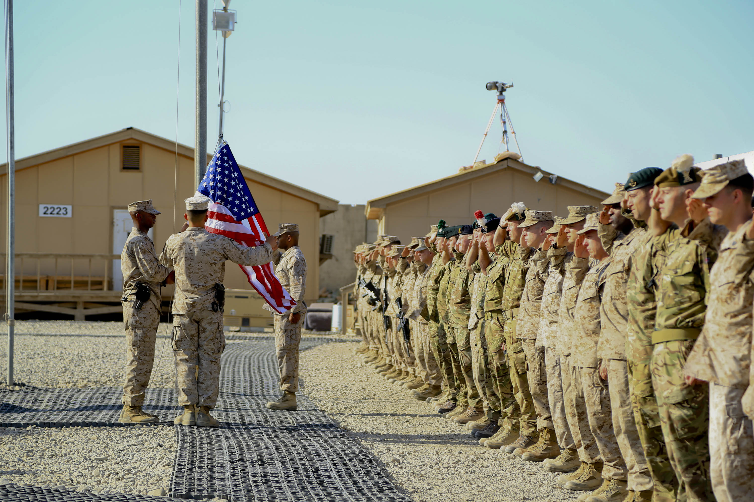 Coalition forces salute the American flag during a 9/11 ceremony on ...