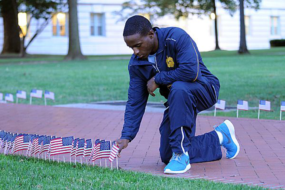 U.S. Navy Petty Officer 2nd Class Chad J. Rogers places an American ...