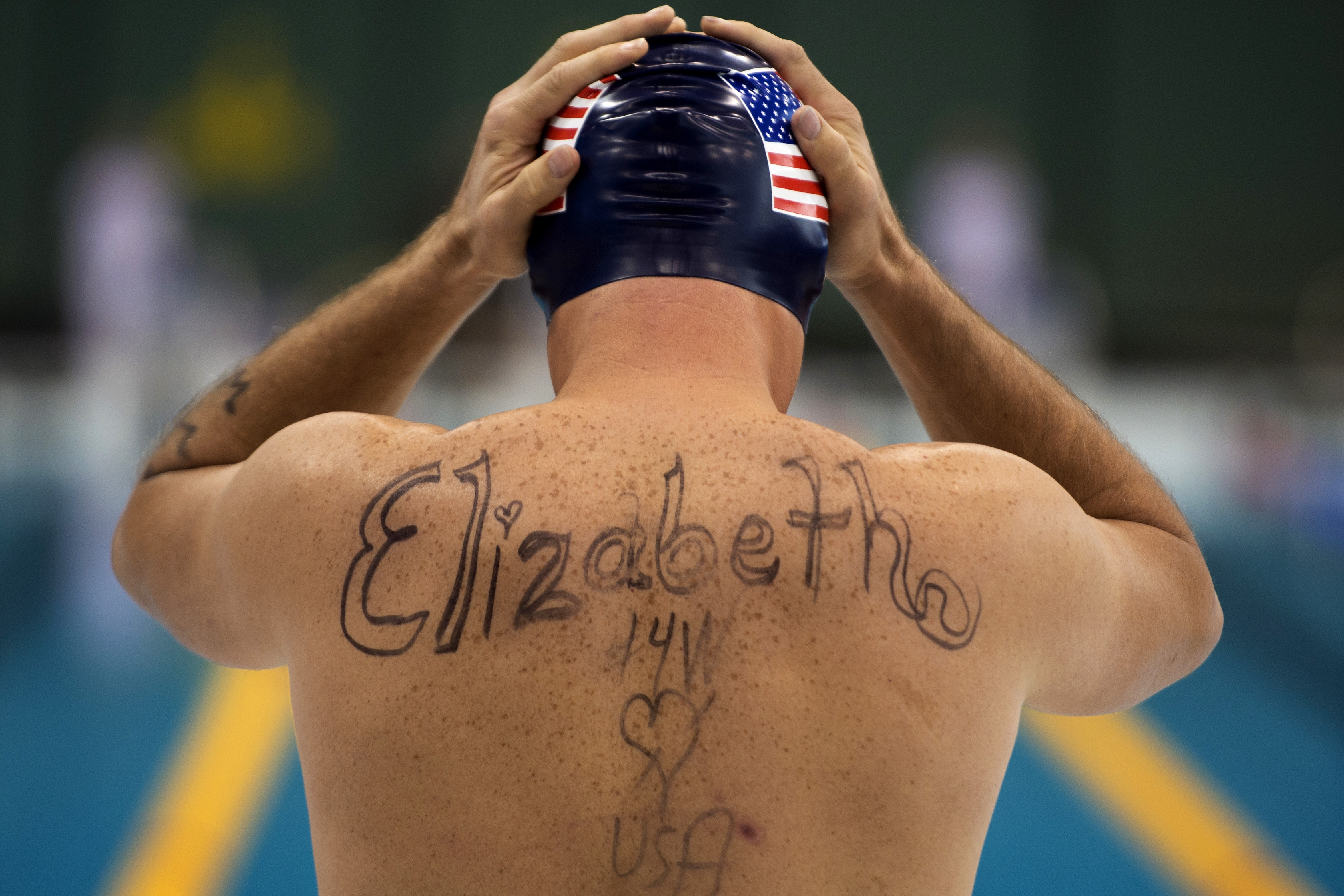 Retired U.S. Navy aircrewman Brett Parks fixes his swimming cap before ...