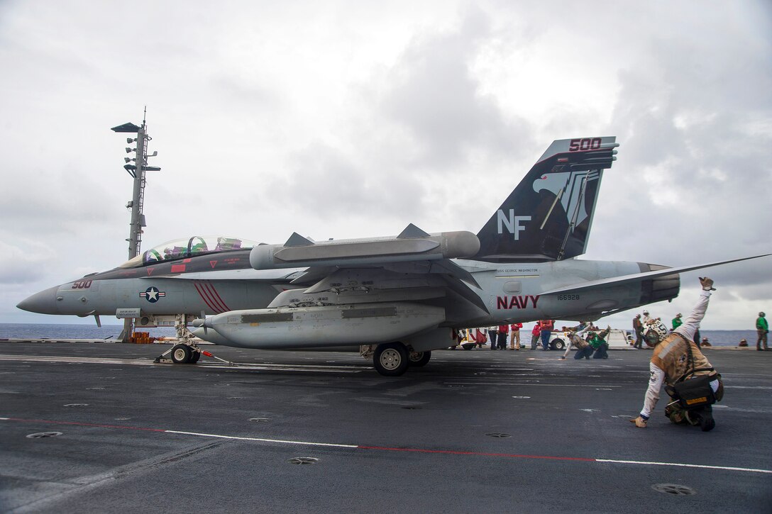 U.S. Navy Petty Officer 2nd Class Chad Lester, bottom-right, gives the ...