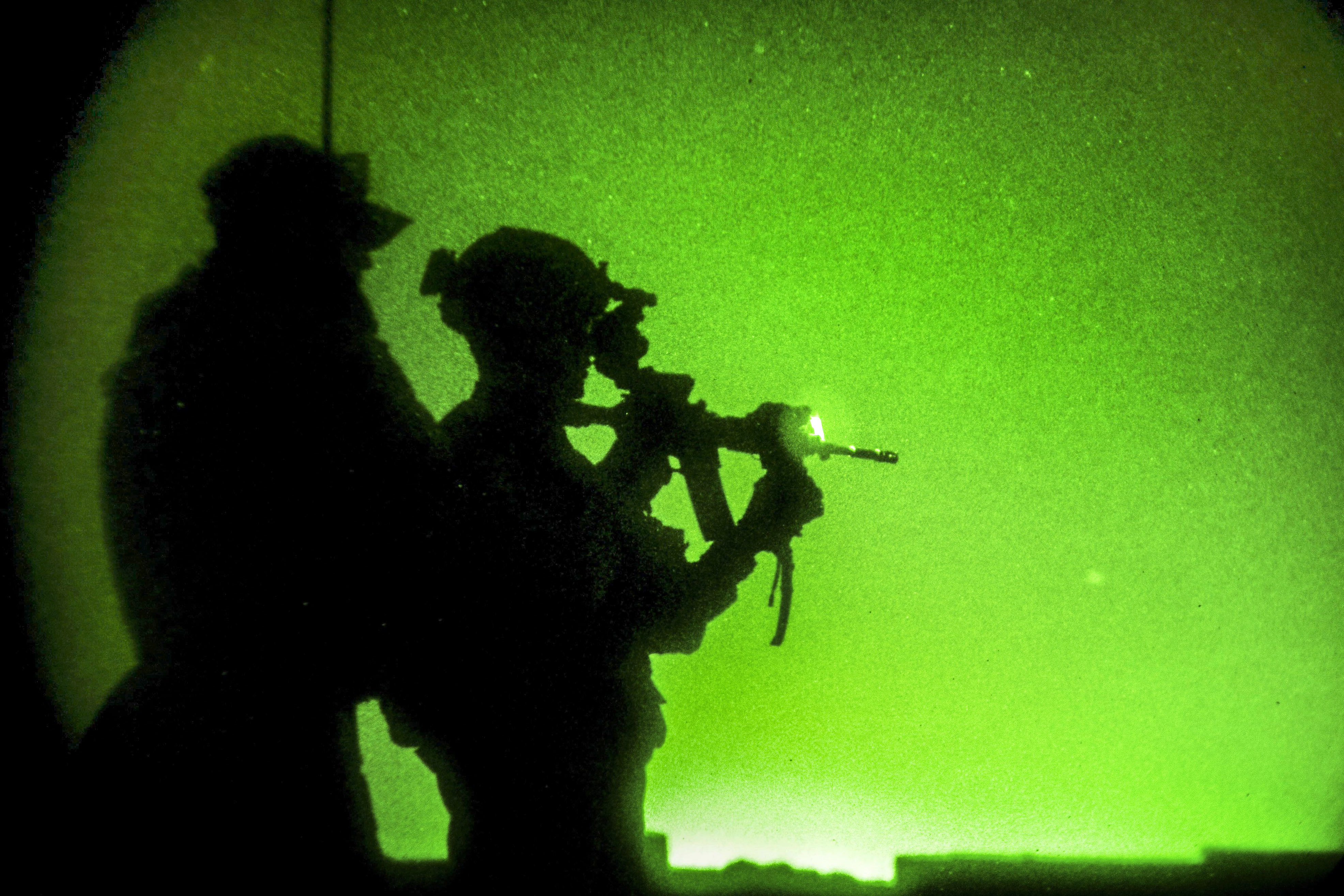 U.S. Army 1st Lt. James Lockett, right, stands next to a linguist and ...