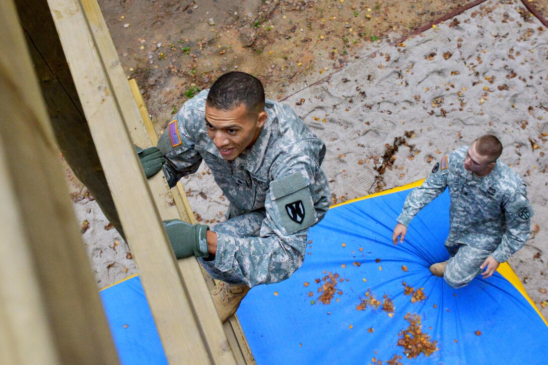 U.S. Army Spc. James Simo, left, negotiates an obstacle during the ...