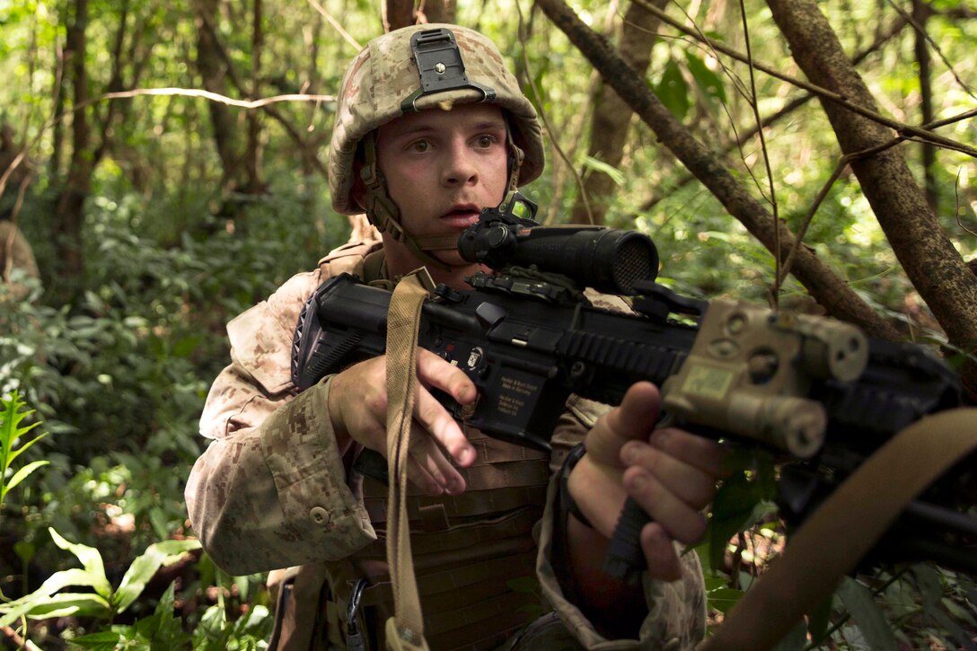 U.S. Marines make their way to a compound held by members of the Guam ...
