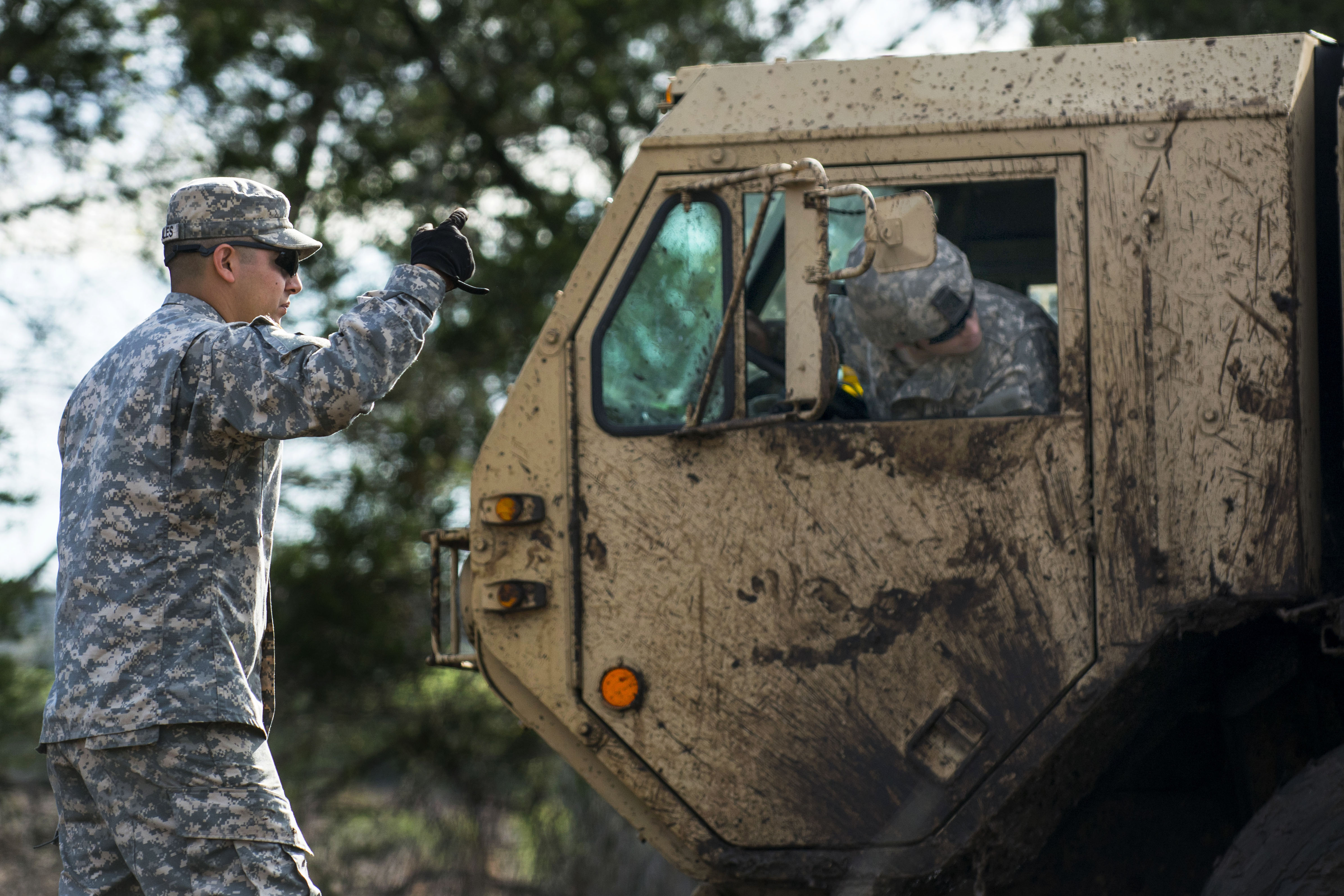 Army Sgt. Robert Gonzales, left, helps guide a recovery vehicle to free ...
