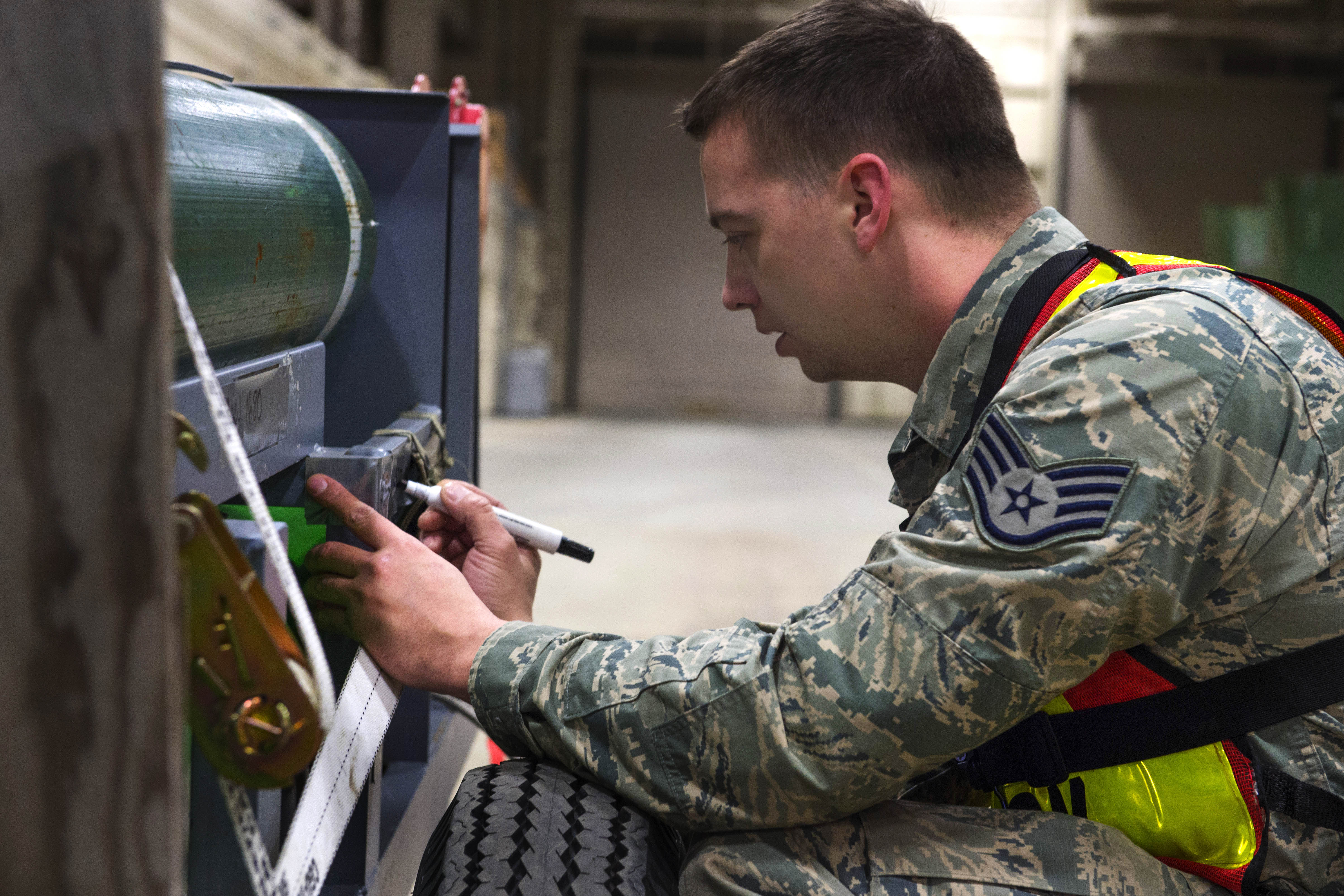 Air Force Staff Sgt. John Cunningham labels palletized cargo during ...