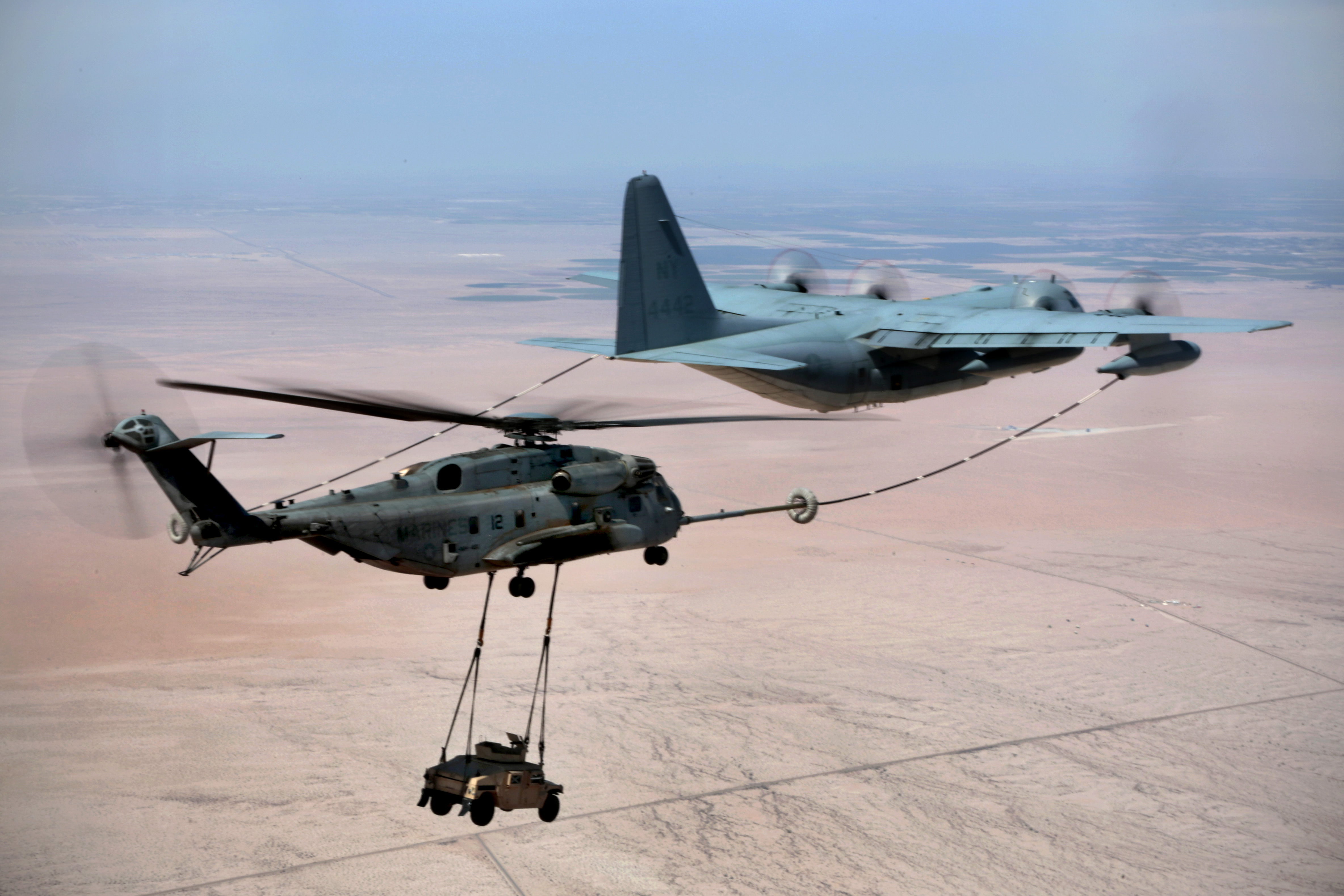 A Marine CH-53E Super Stallion helicopter conducts aerial refueling during slingload training ...