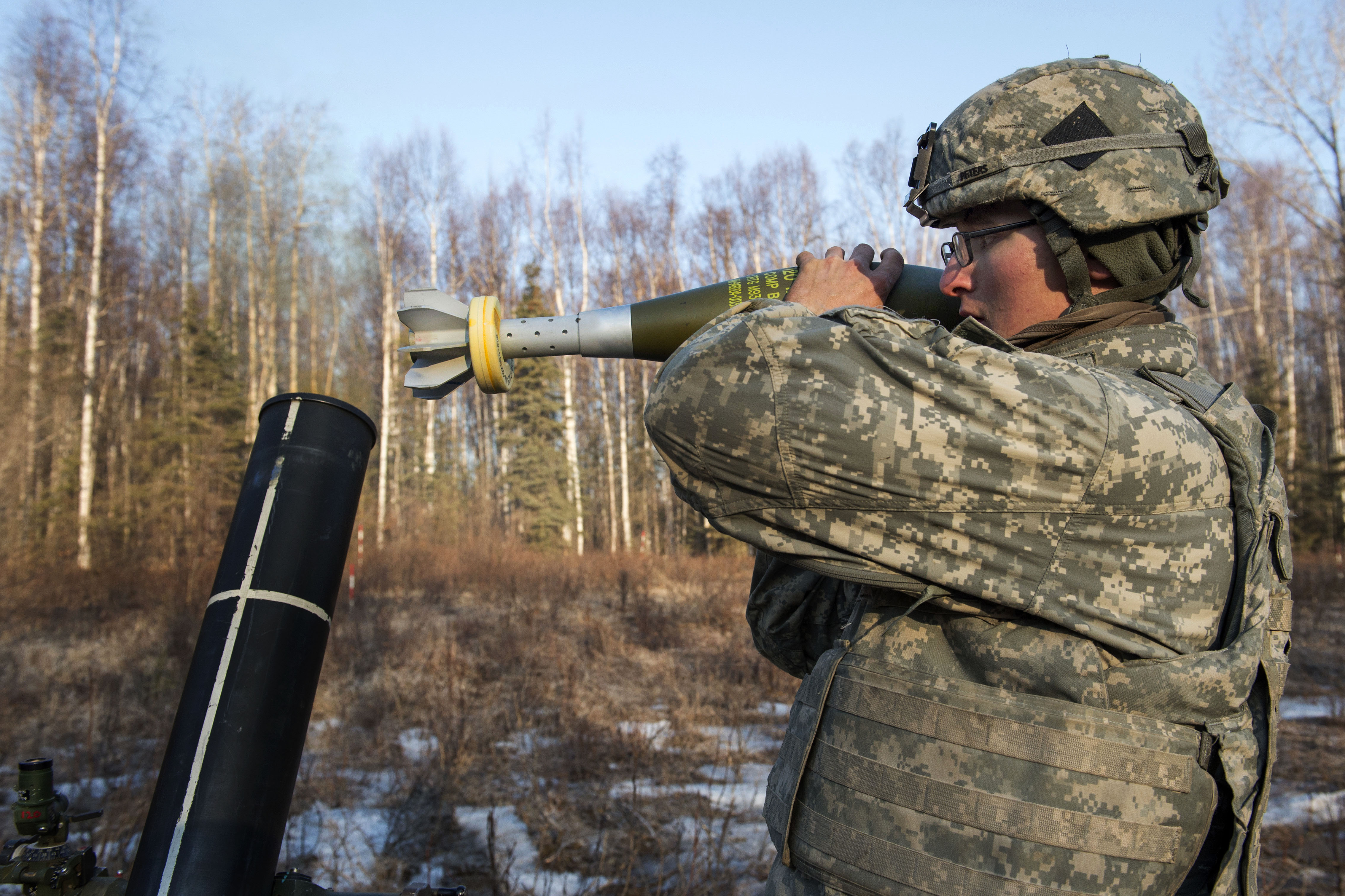 Army Pvt. Corey Peters loads a live round into an M121 120-mm mortar ...