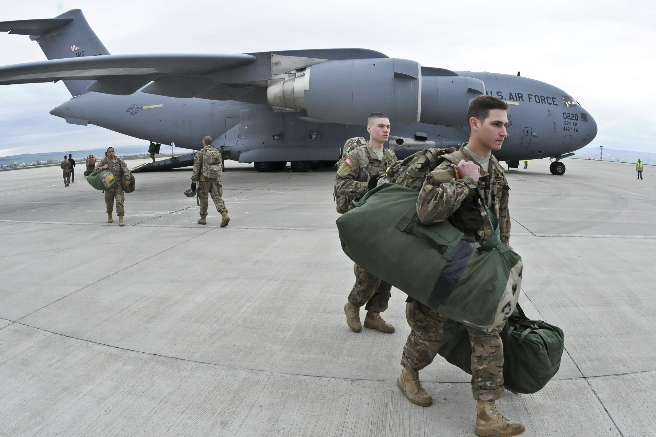 U.S. soldiers walk on the flight line toward their Stryker Combat ...