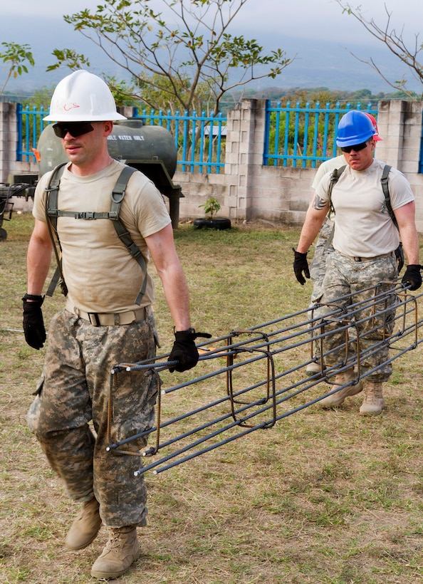 Army Spcs. Dustin J. Mattos, right, and Phillip E. Cody carry a rebar ...