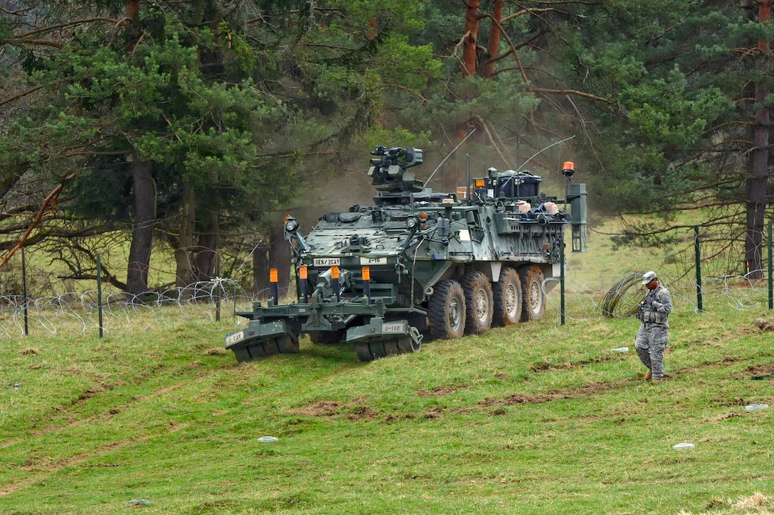 U.S. soldiers in a Stryker combat vehicle equipped with a mine plow ...