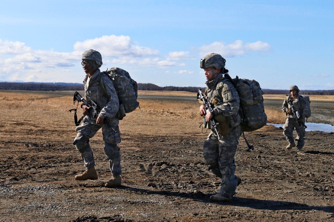 Paratroopers walk off Malemute drop zone to a rally point after an ...