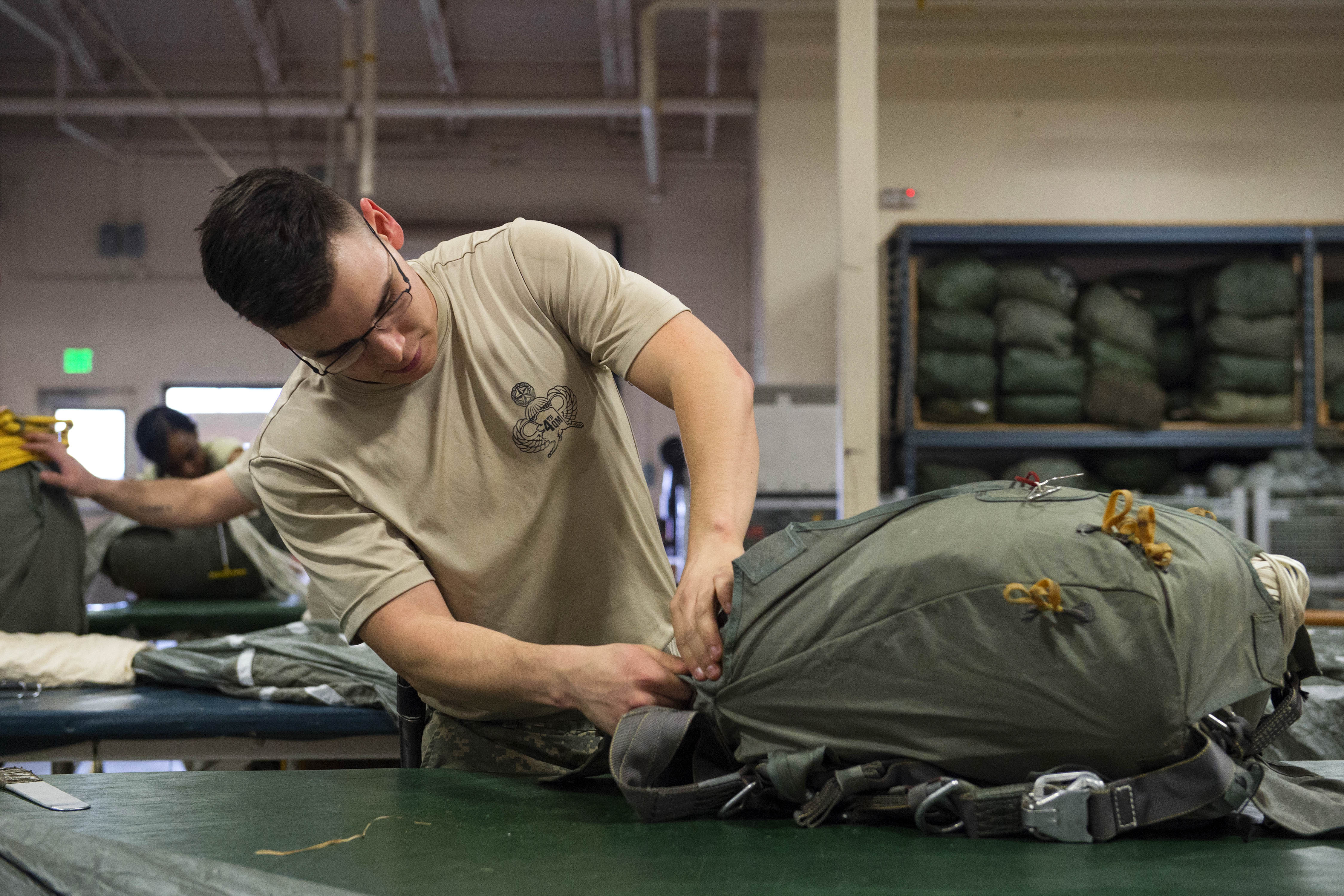 Army Spc. Brandon Stewart packs a T-11 advanced tactical parachute ...