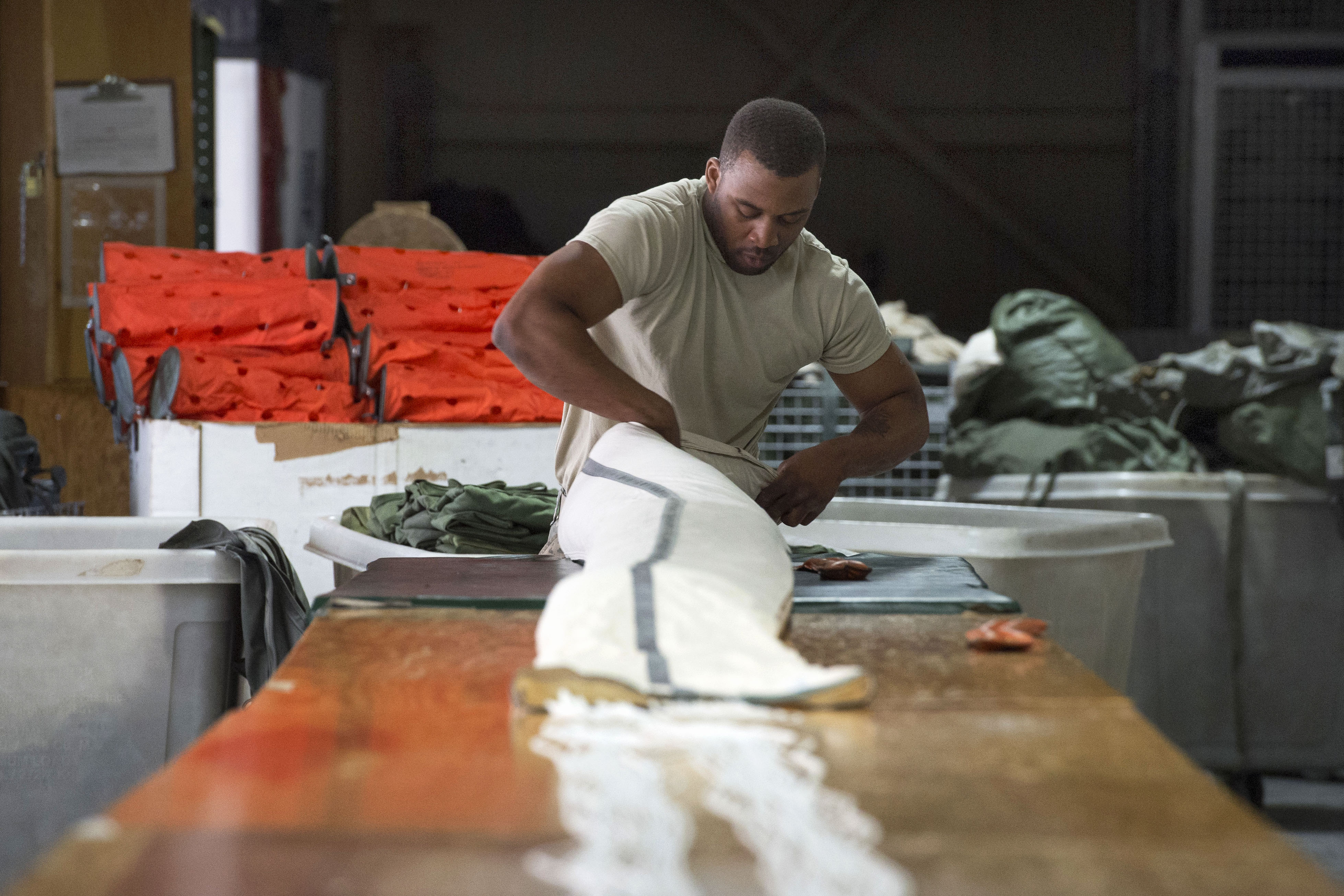 Army Pfc. Kadeem Hazel packs a T-11 advanced tactical parachute system ...