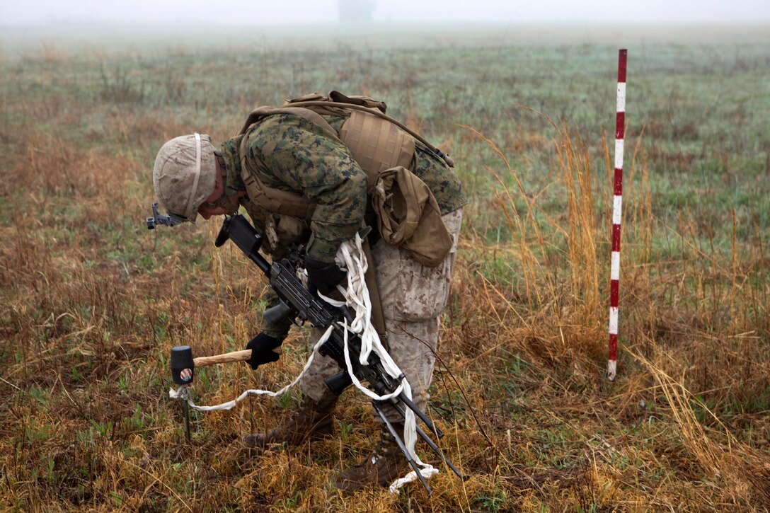 Marine Lance Cpl. Nick Perreault marks the placement of an M777A2 ...