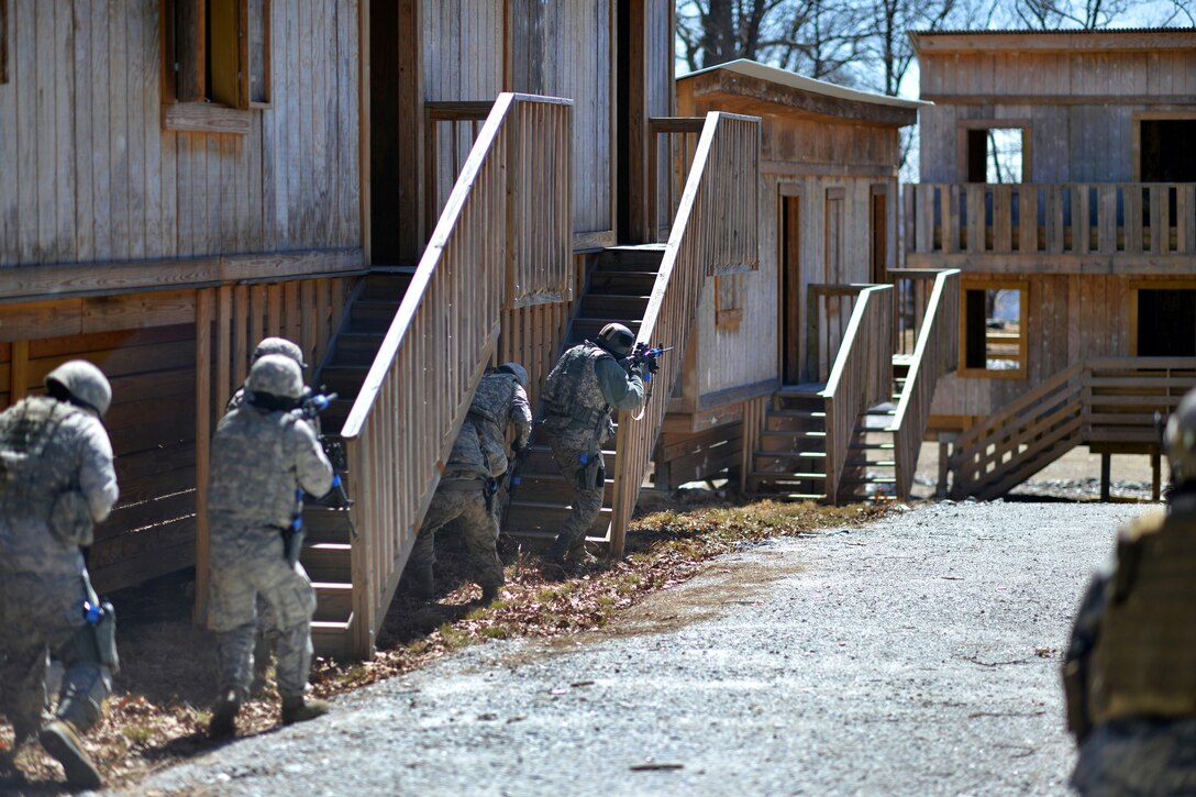 Airmen move along a building toward an objective during a training ...
